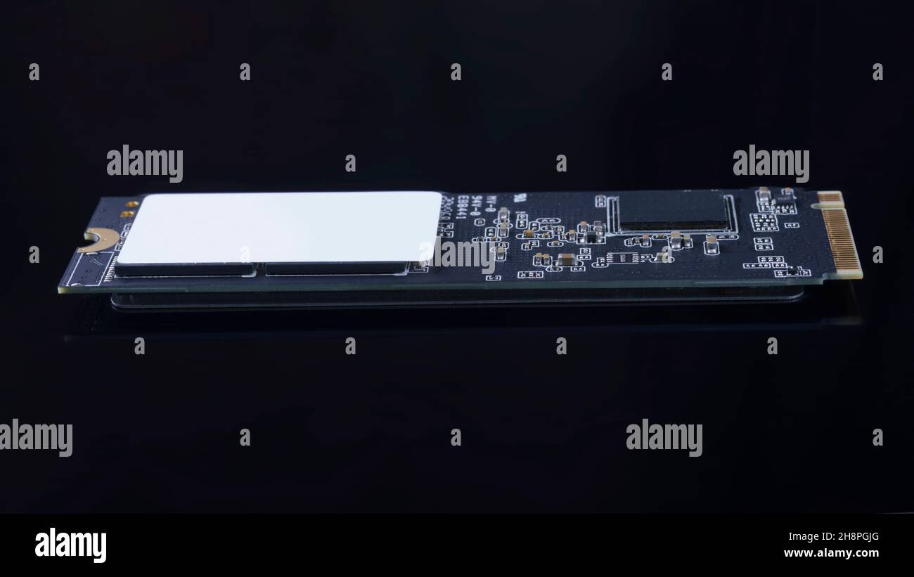 SSD M2 disk close up side view. On dark background with reflection ...