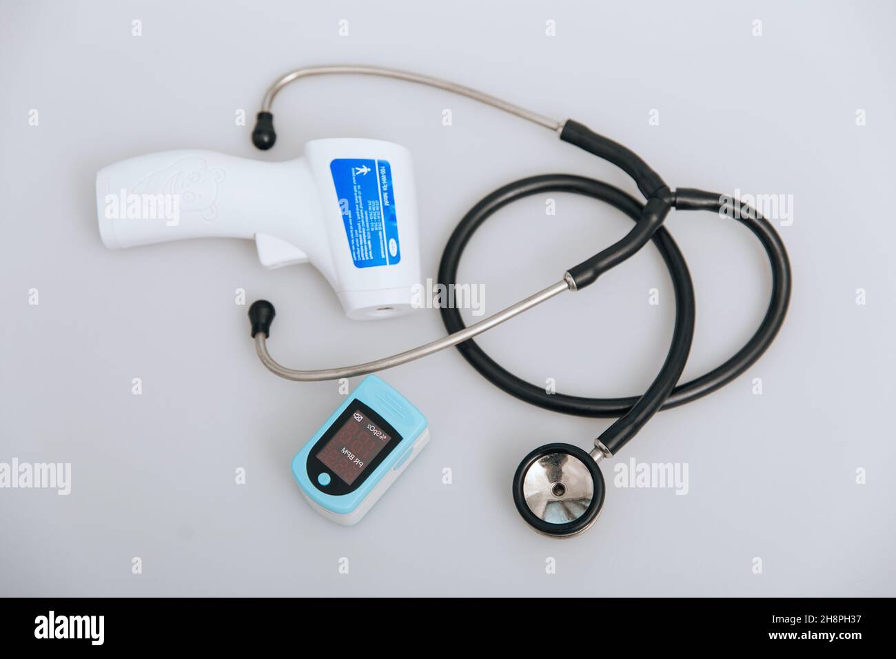 Stethoscope, pulse oximeter and thermometer gun on white background ...
