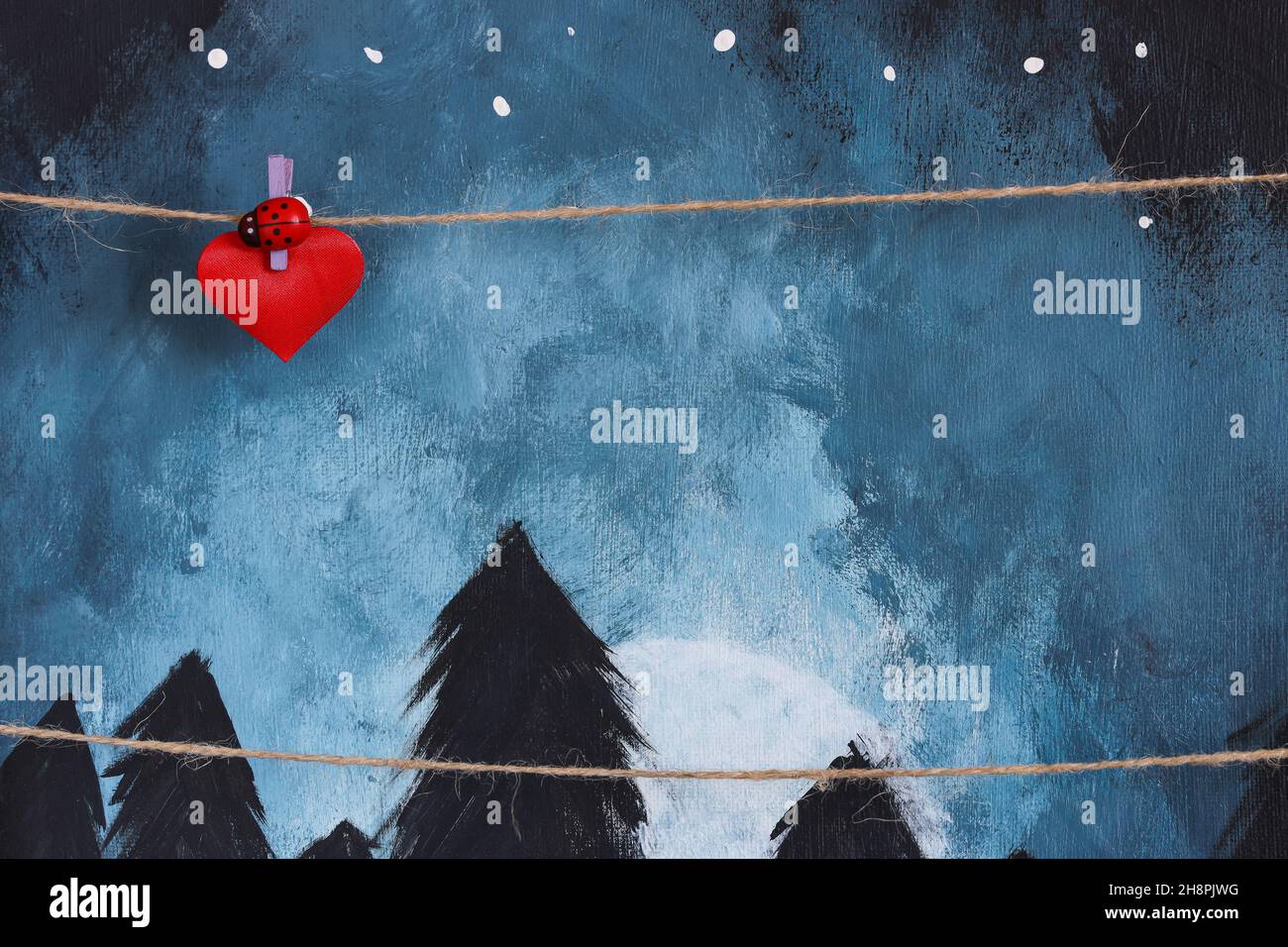 Red heart stuck on rope with pegs on oil painting background, pine ...