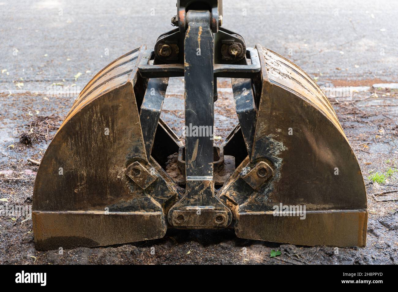 Excavator plate parked on a sidewalk Stock Photo - Alamy