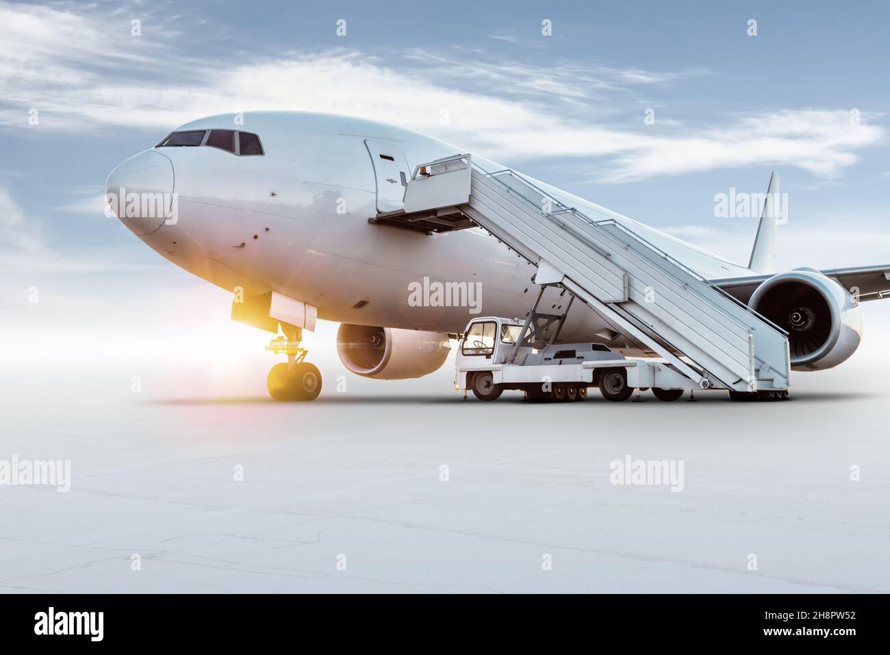 Wide body passenger airplane with boarding stairs at the airport apron ...