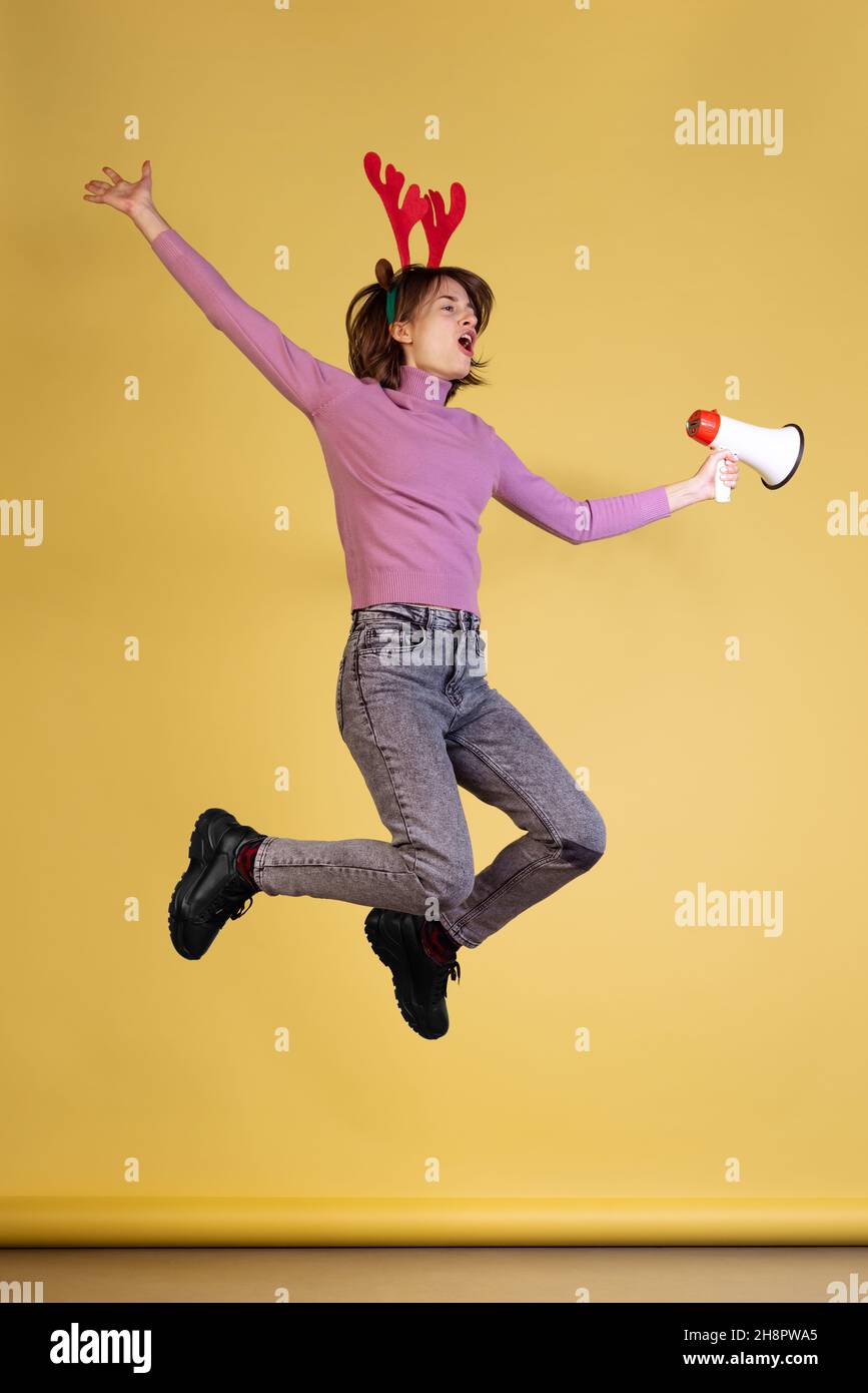 Full-length portrait of excited young woman cheerfully shouting in ...