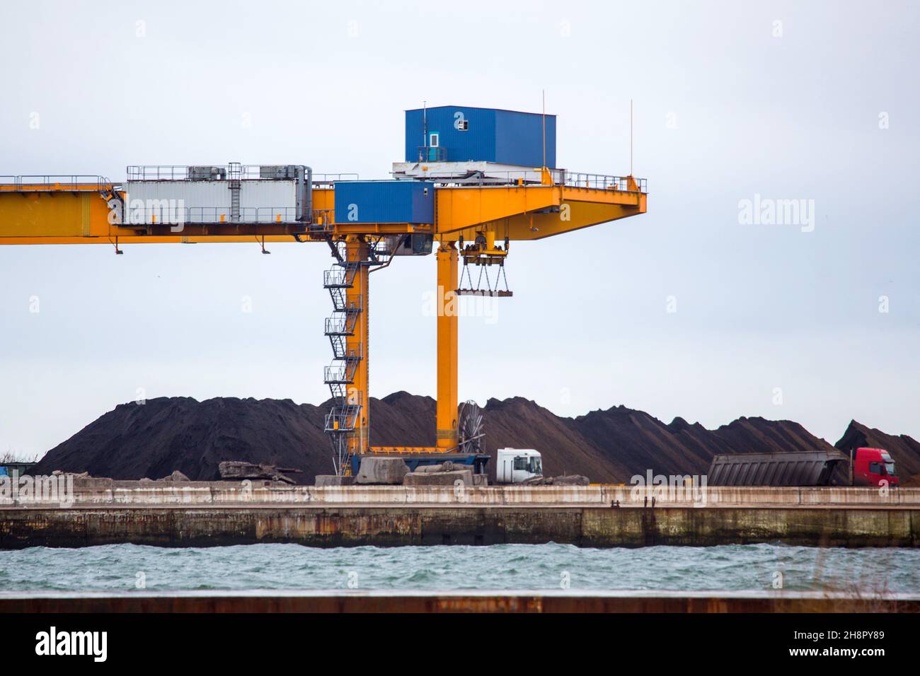 coal terminal of seaport. Heaps of coal in port awaiting loading on ...