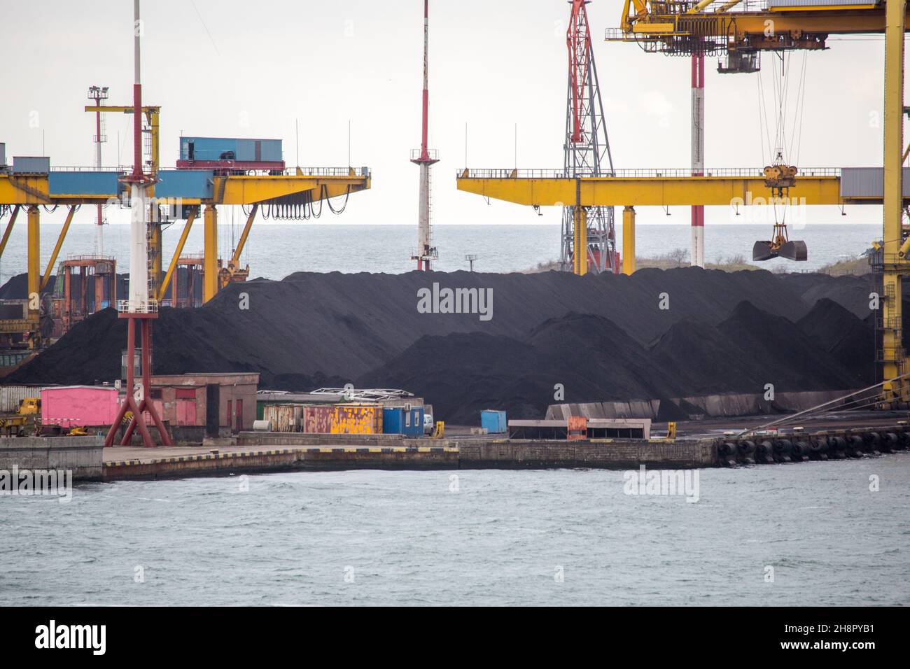 coal terminal of seaport. Heaps of coal in port awaiting loading on ...