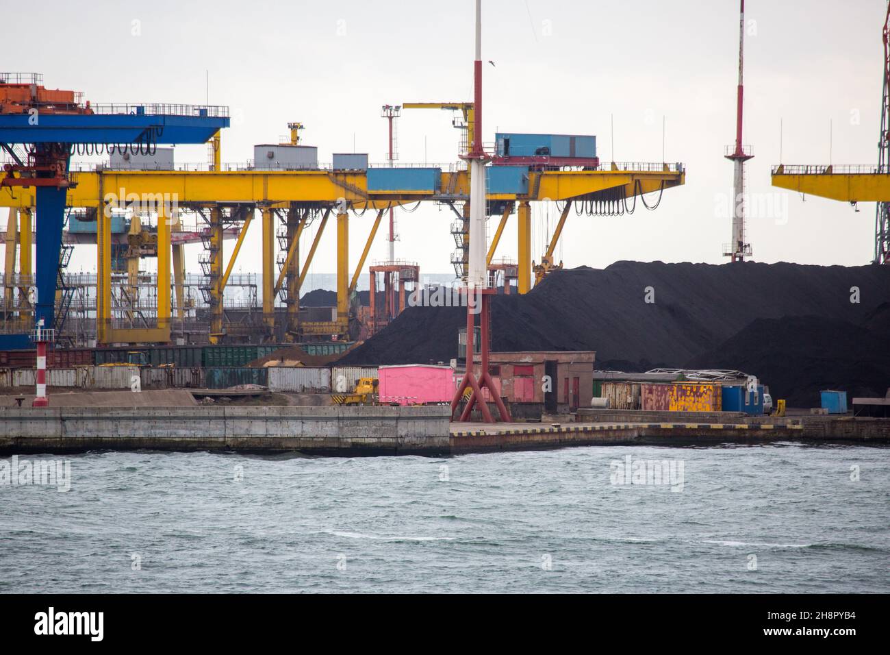 coal terminal of seaport. Heaps of coal in port awaiting loading on ...
