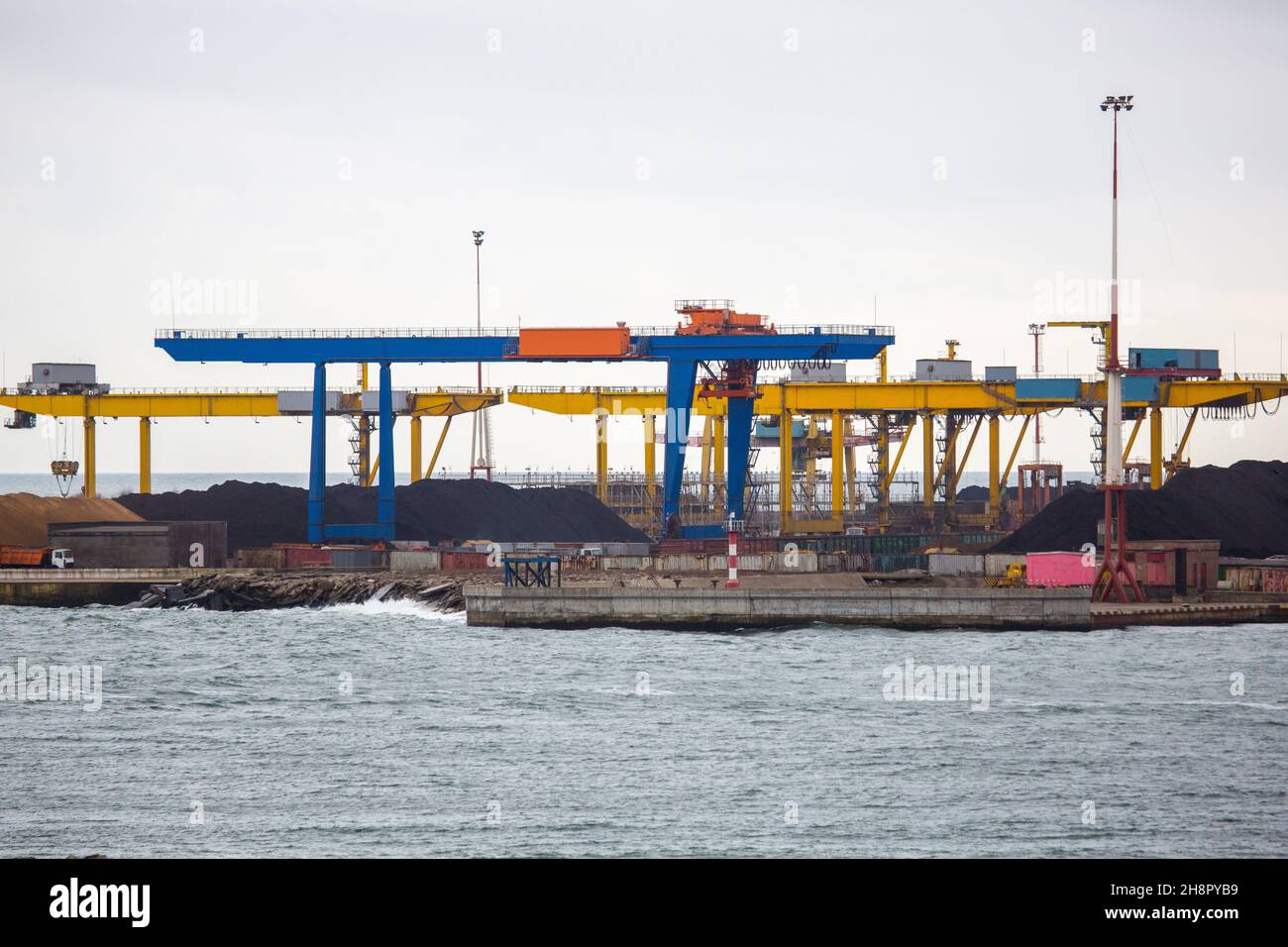 coal terminal of seaport. Heaps of coal in port awaiting loading on ...