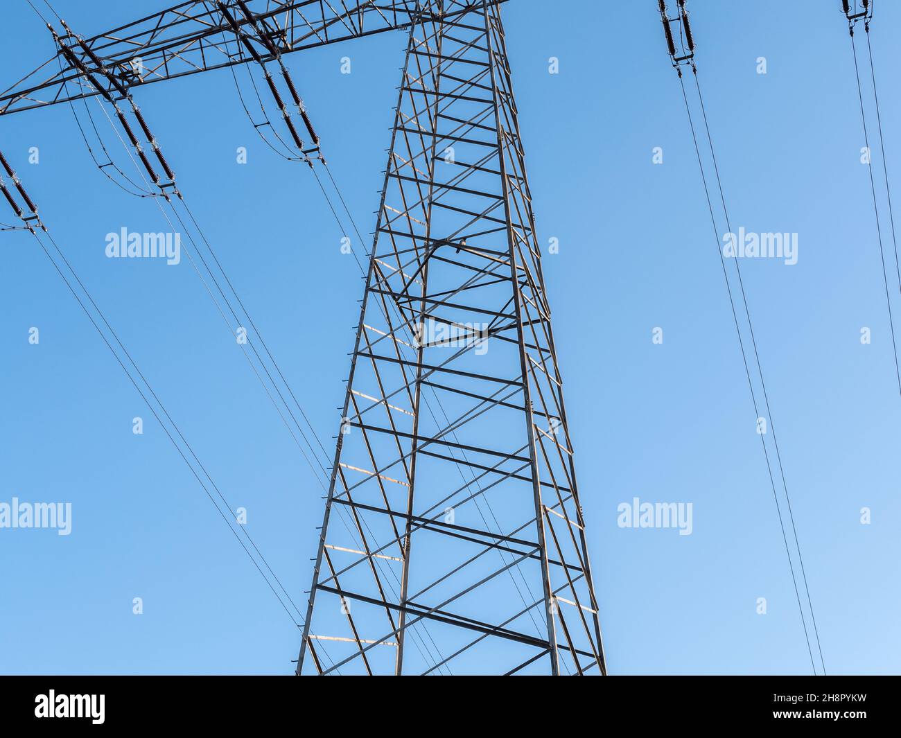 Electricity pylon in the middle from below under a blue sky Stock Photo ...