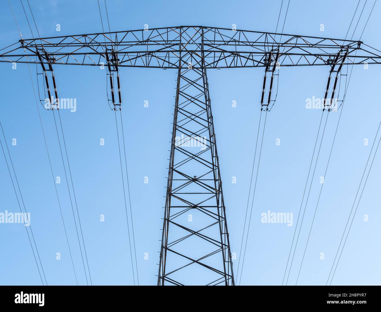 Electricity pylon in the middle from below under a blue sky Stock Photo ...