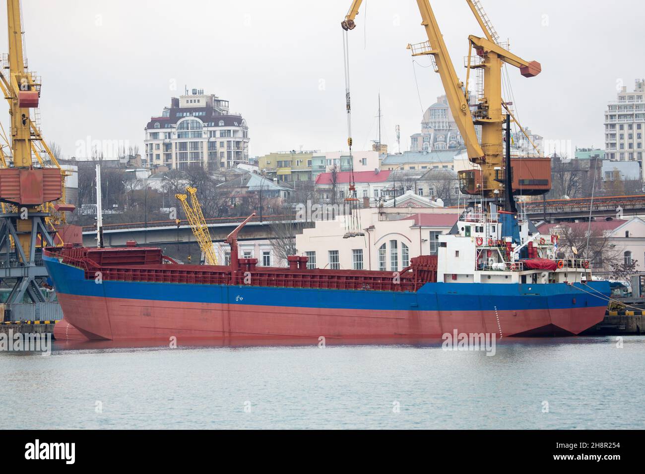 Vessel dry cargo on loading, unloading in port. Bulker in port. port crane loads bulk cargo at ...