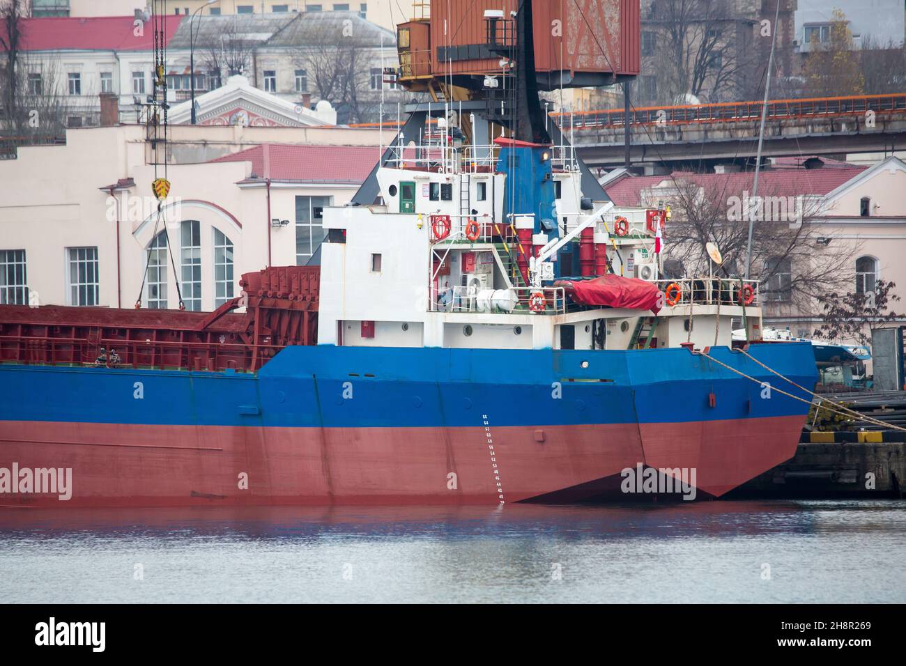 Vessel dry cargo on loading, unloading in port. Bulker in port. port crane loads bulk cargo at ...