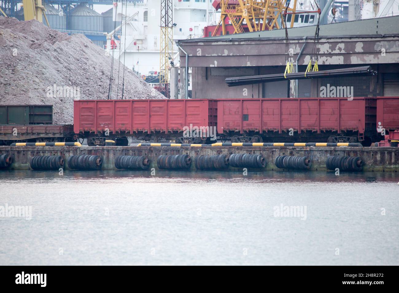 Railroad cars in port for loading unloading. Port cranes unload, load ...