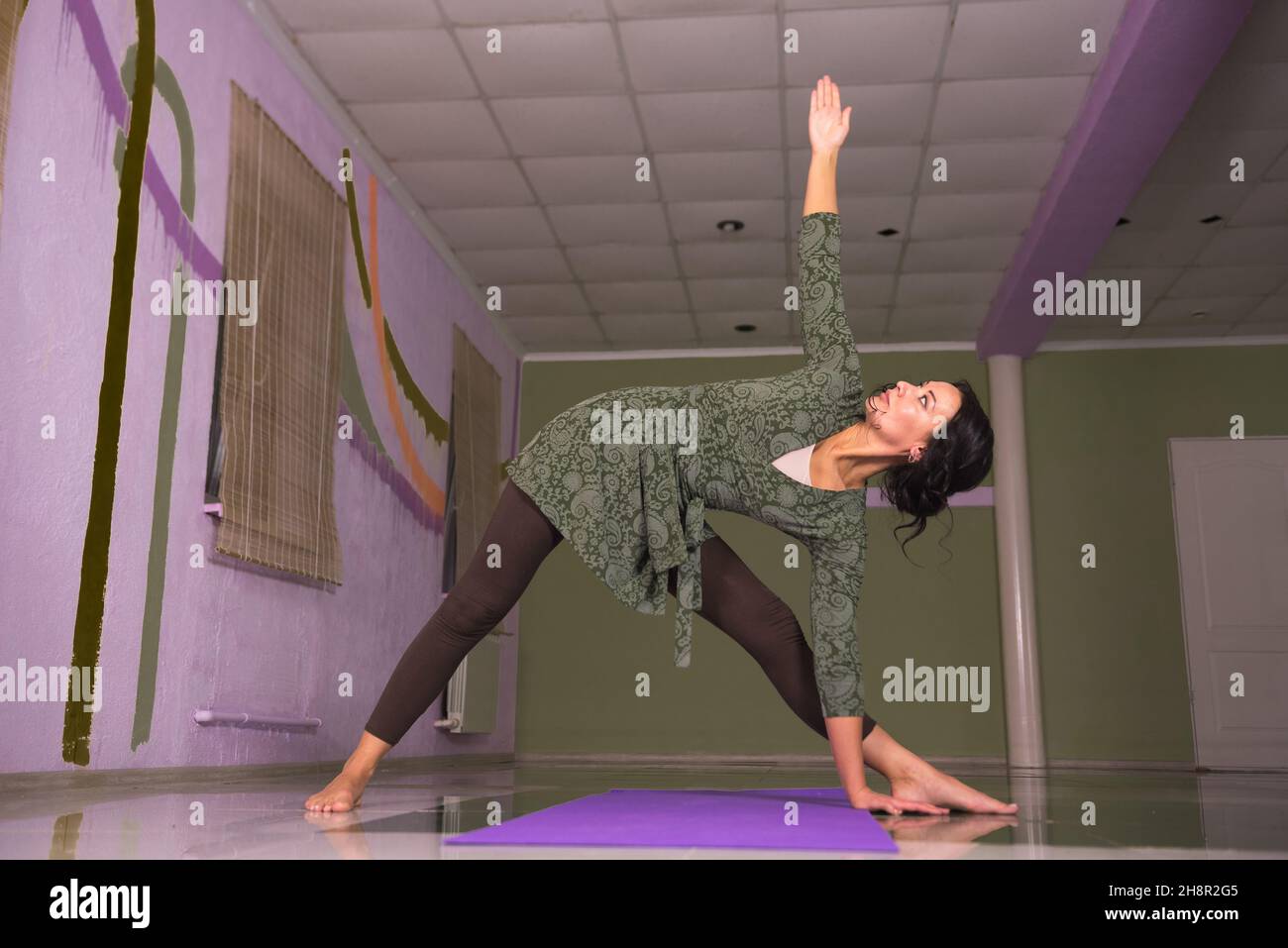 Professional yoga trainer showing yoga asana in the gym Stock Photo - Alamy