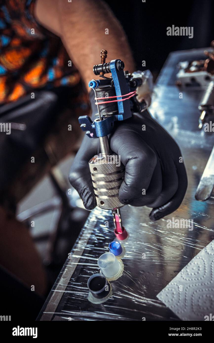 Hand of master of the art of tattooing with a tattoo gun Stock Photo ...
