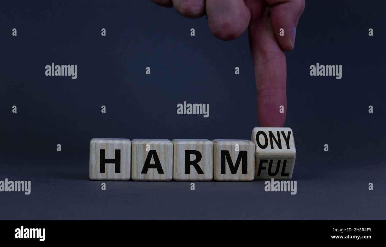 From harmful to harmony. Businessman turns the wooden cube and changes ...