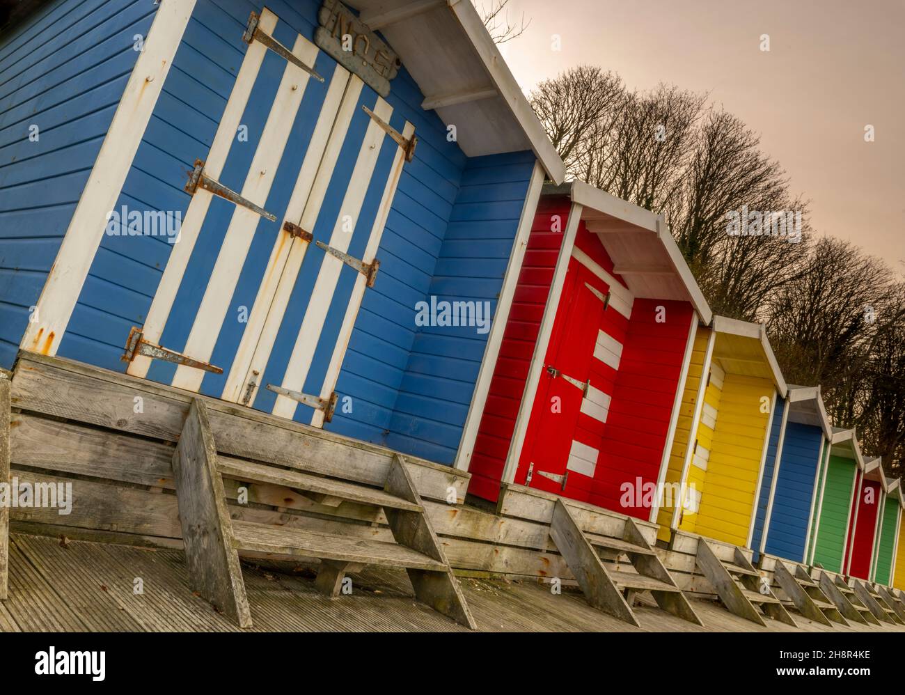 Row of colourful beach huts on the Isle of Wight coastline, line of ...