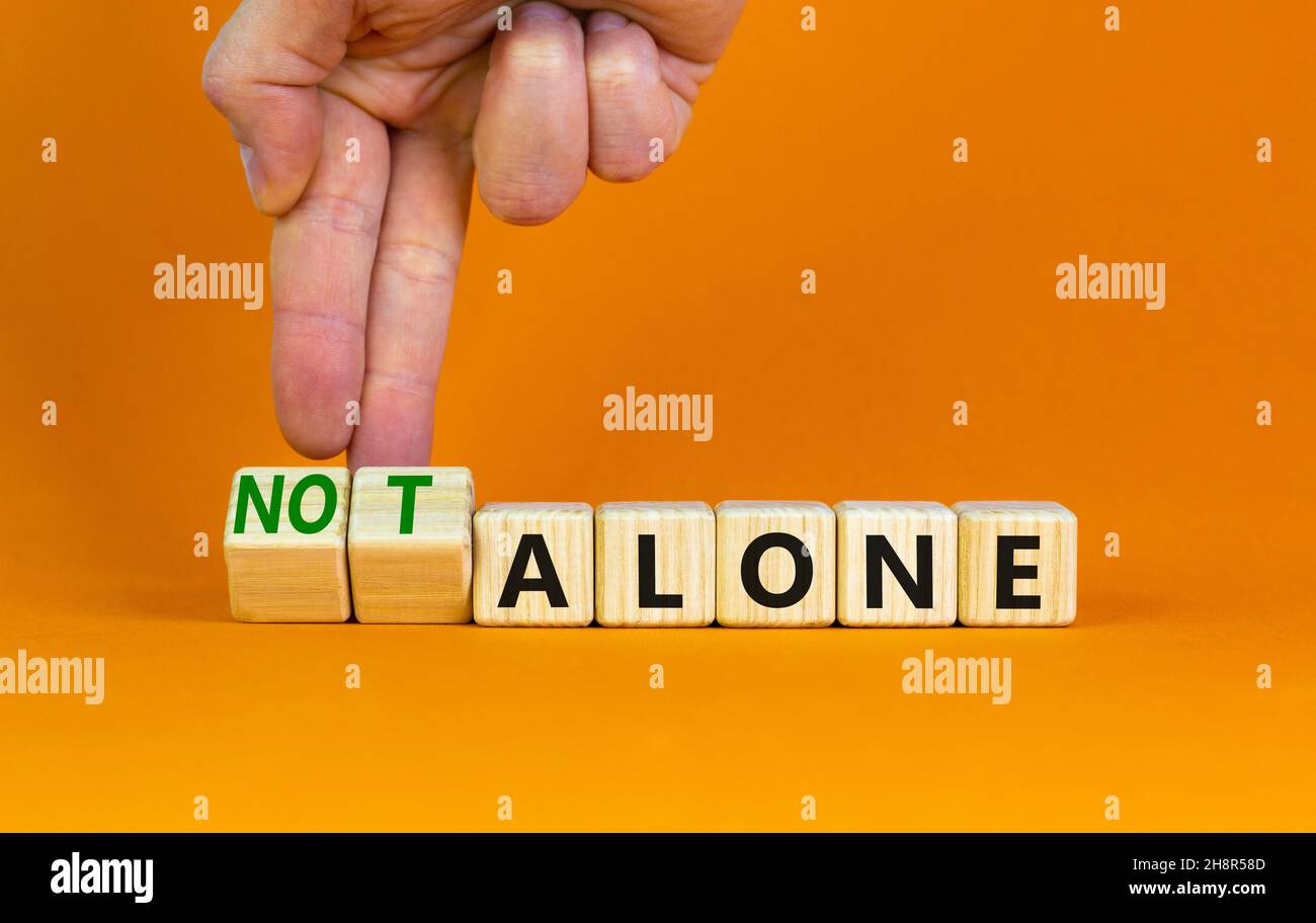 You are not alone symbol. Businessman turns wooden cubes and changes ...