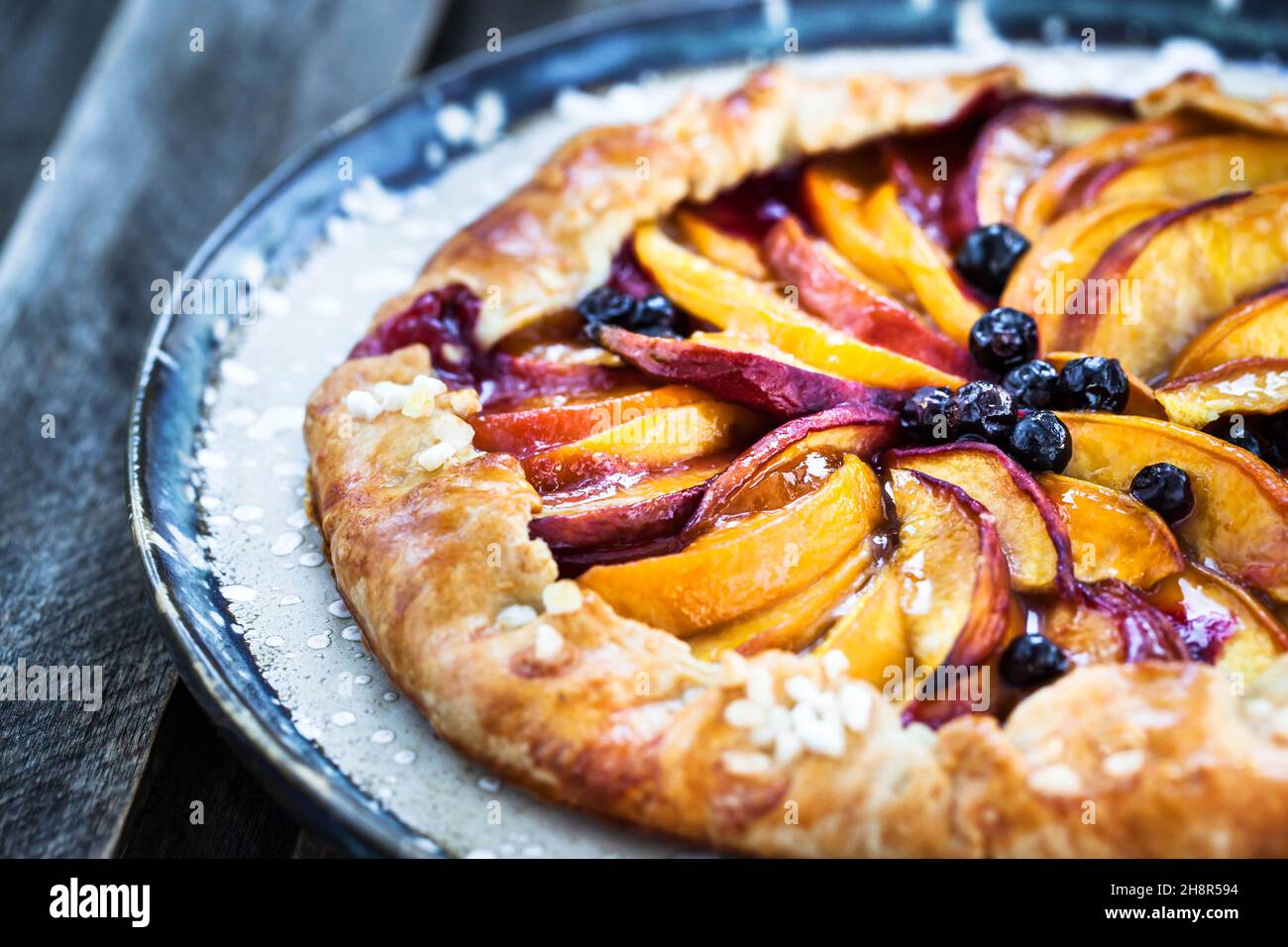 Rustic sweet open pie (galette) with peach and berry Stock Photo - Alamy
