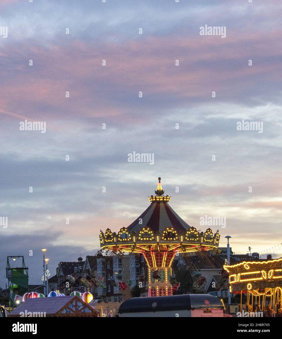 Beautiful pink sunset sky over a colourful fair ground Stock Photo - Alamy