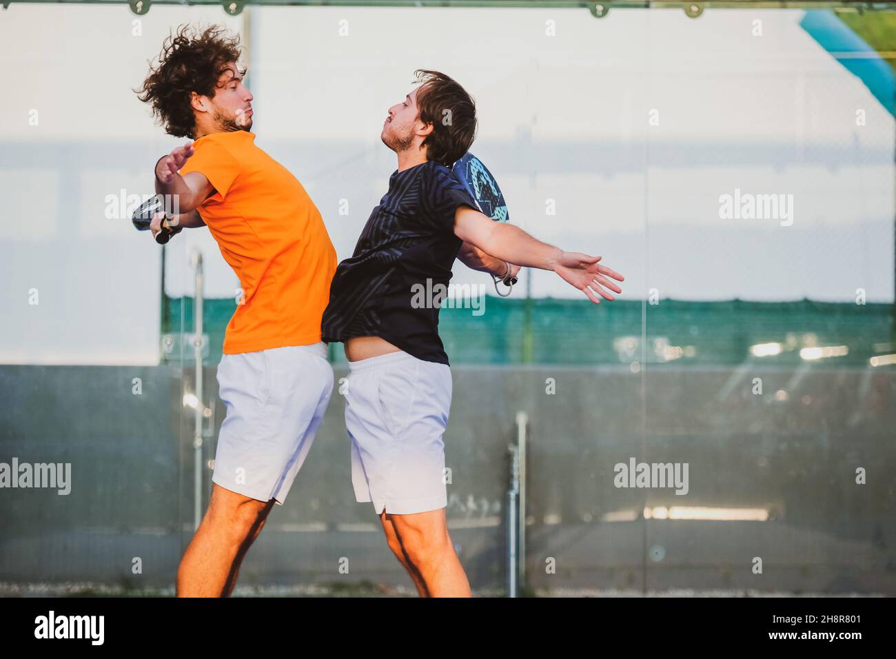 Portrait of two smiling sportsman's posing on padel court outdoor with ...