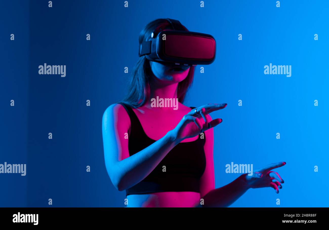 Portrait of woman video game designer wearing VR headset and interact ...