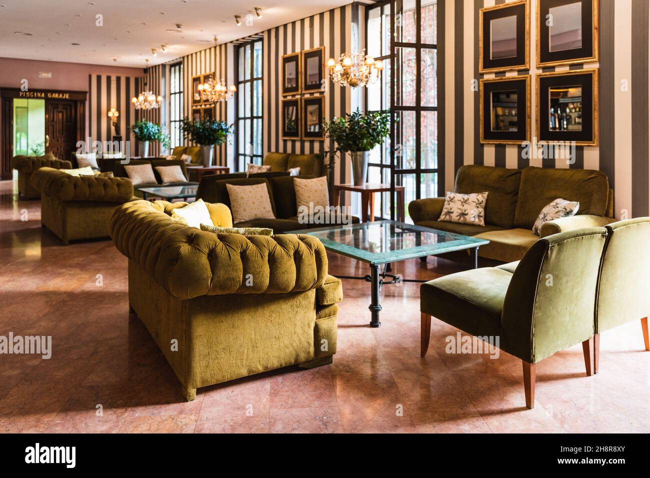 Hotel reception hall with green sofas and low glass tables without ...