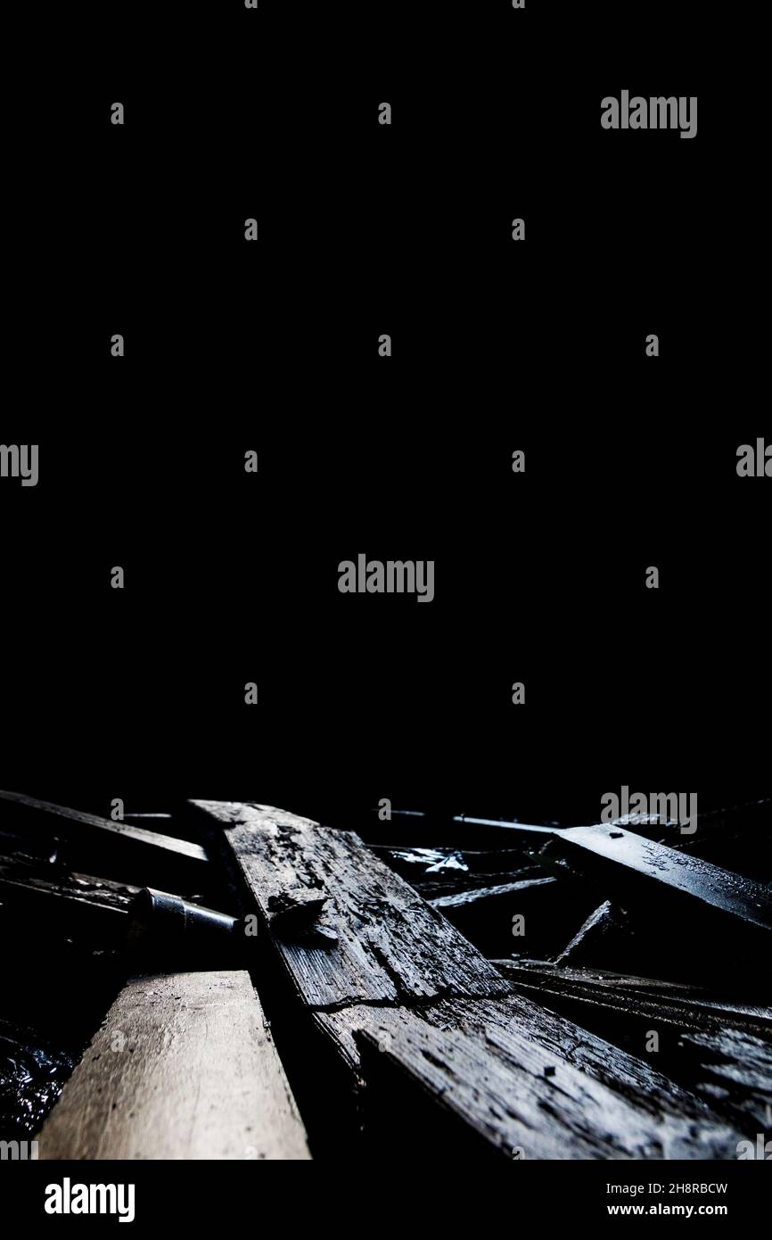 Dark view and selective focus on burned wooden beams and destruction ...