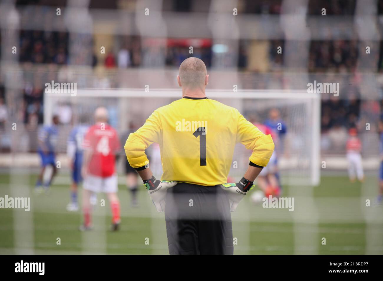 Goalkeeper seen during the football match through the gates Stock Photo ...