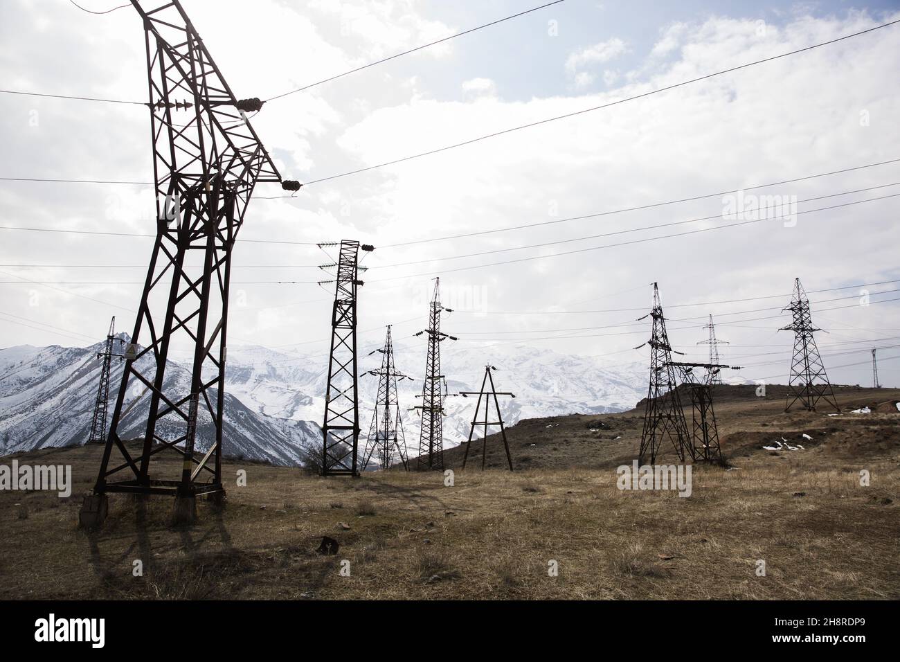 High voltage post with transmission towers Stock Photo - Alamy