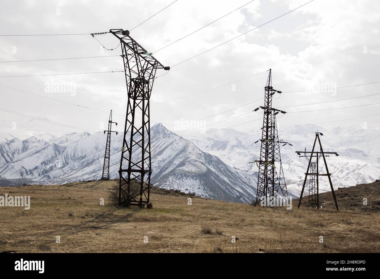 High voltage post with transmission towers Stock Photo - Alamy