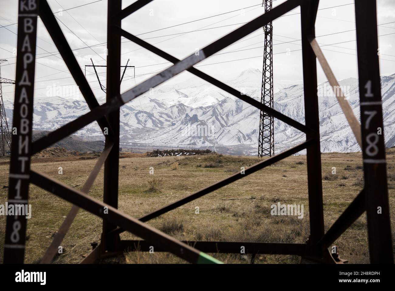 High voltage post with transmission towers Stock Photo - Alamy