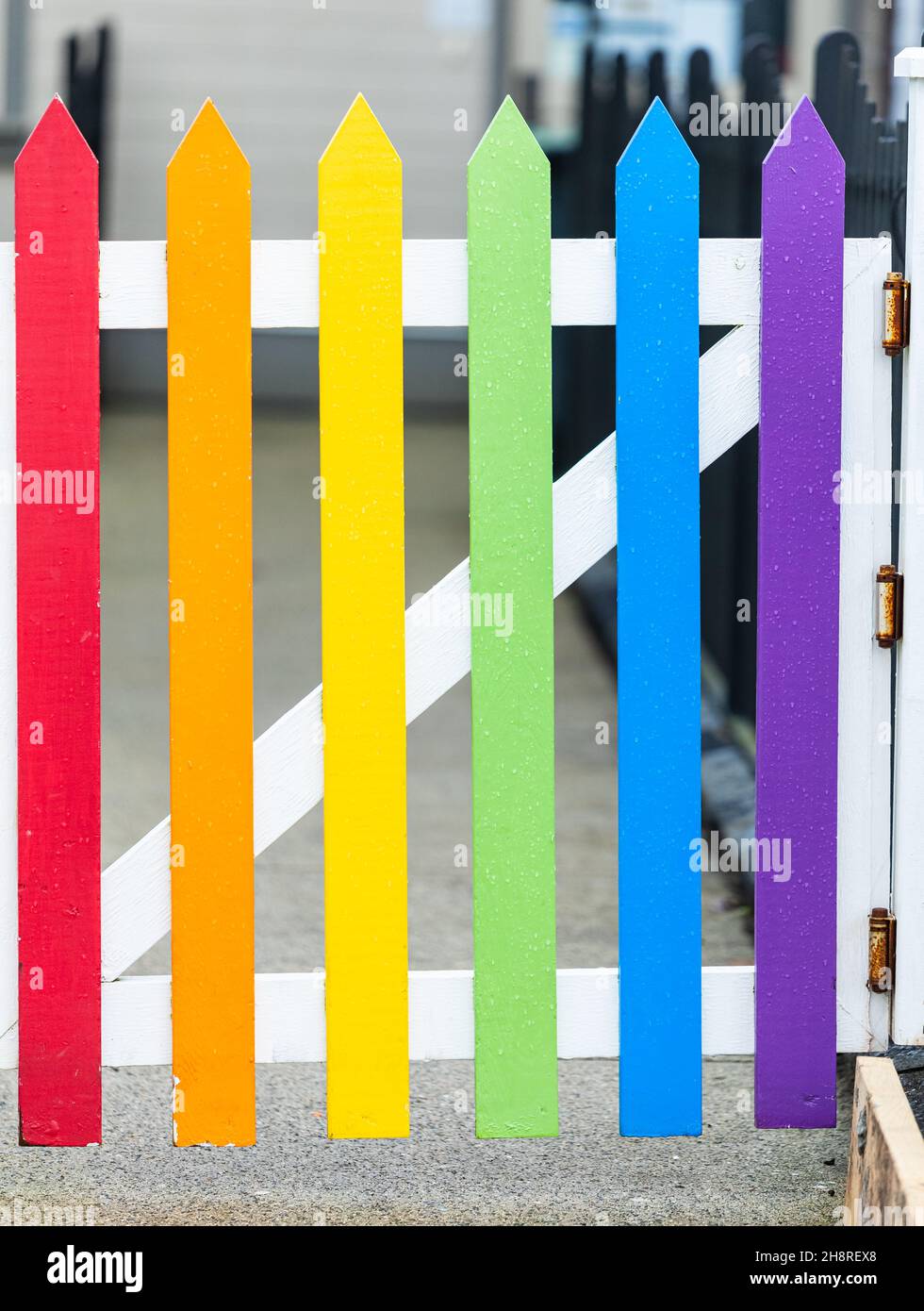 Close-up of a rainbow colored wooden fence gate in a small town Stock ...