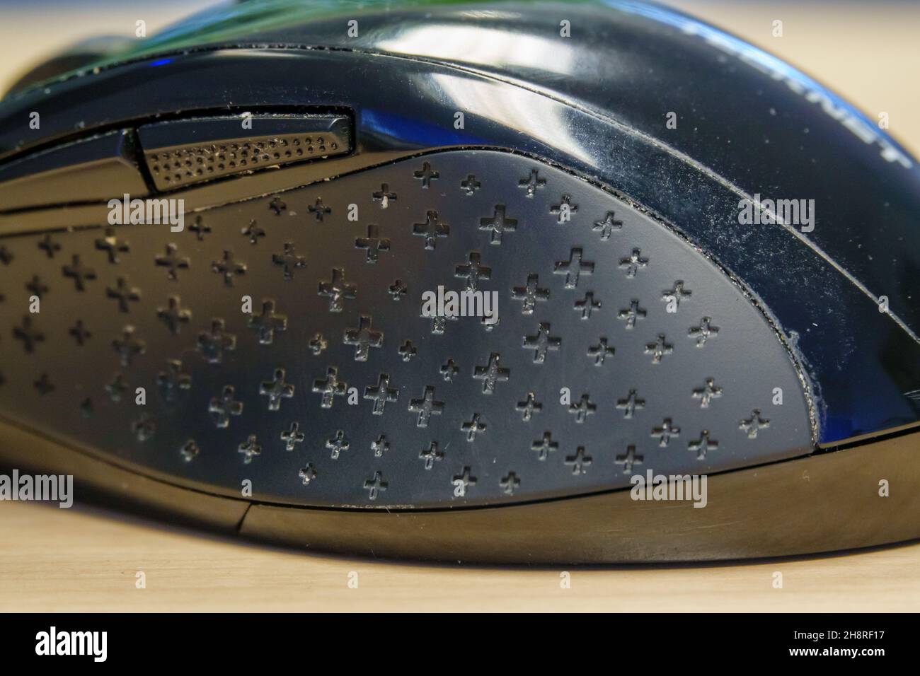 close up of a black wireless computer mouse on a light oak office ...