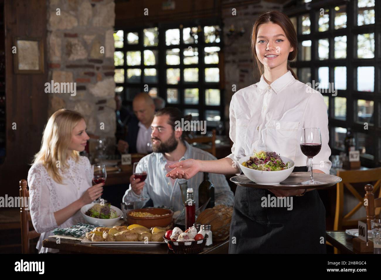 Waitress inviting guests for lunch Stock Photo - Alamy