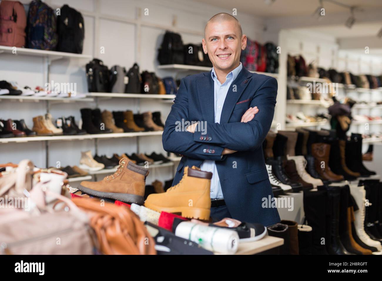 Portrait of positive male shoe seller in shoe store Stock Photo - Alamy