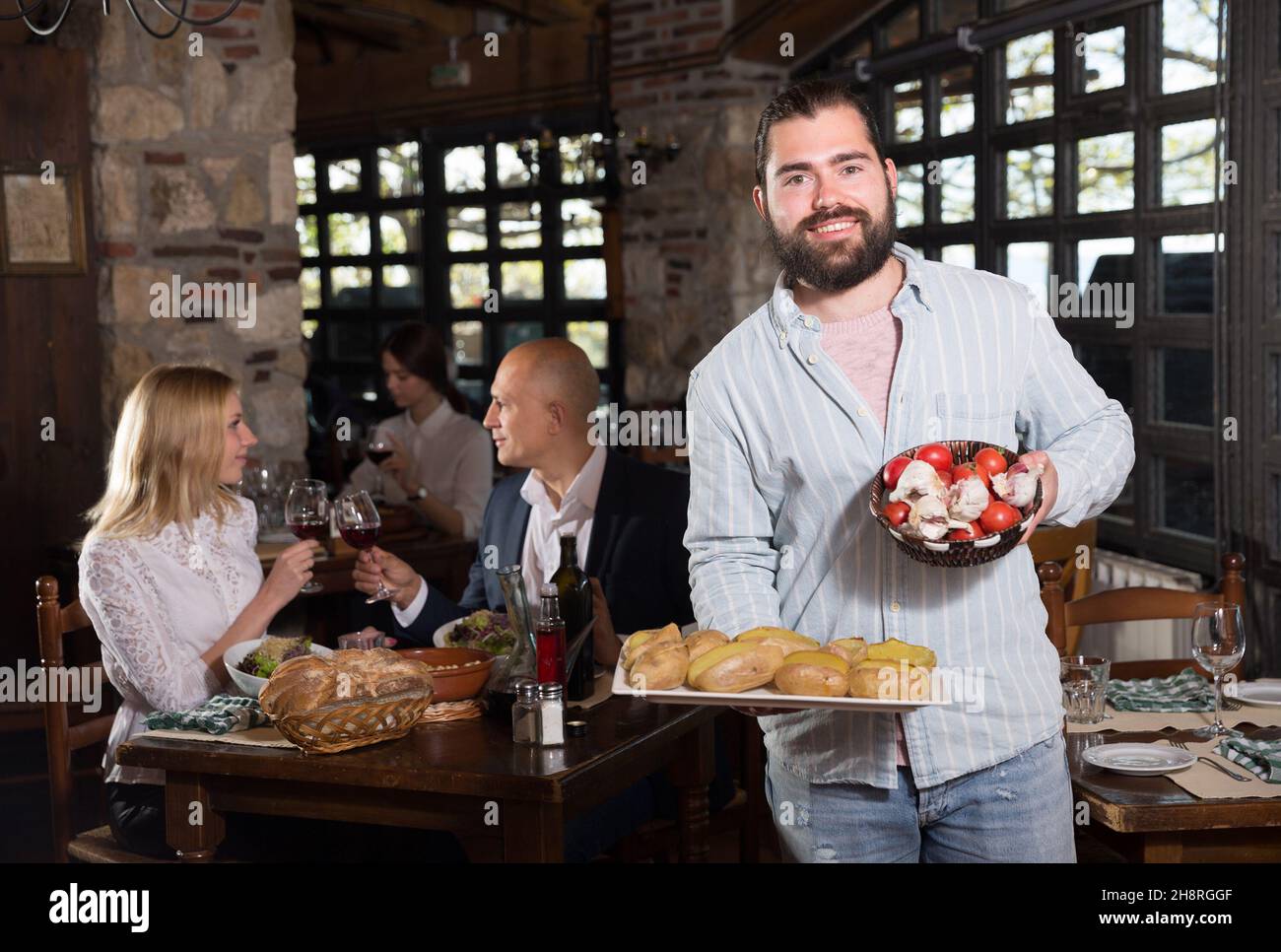 Young owner of country restaurant with traditional meals Stock Photo ...
