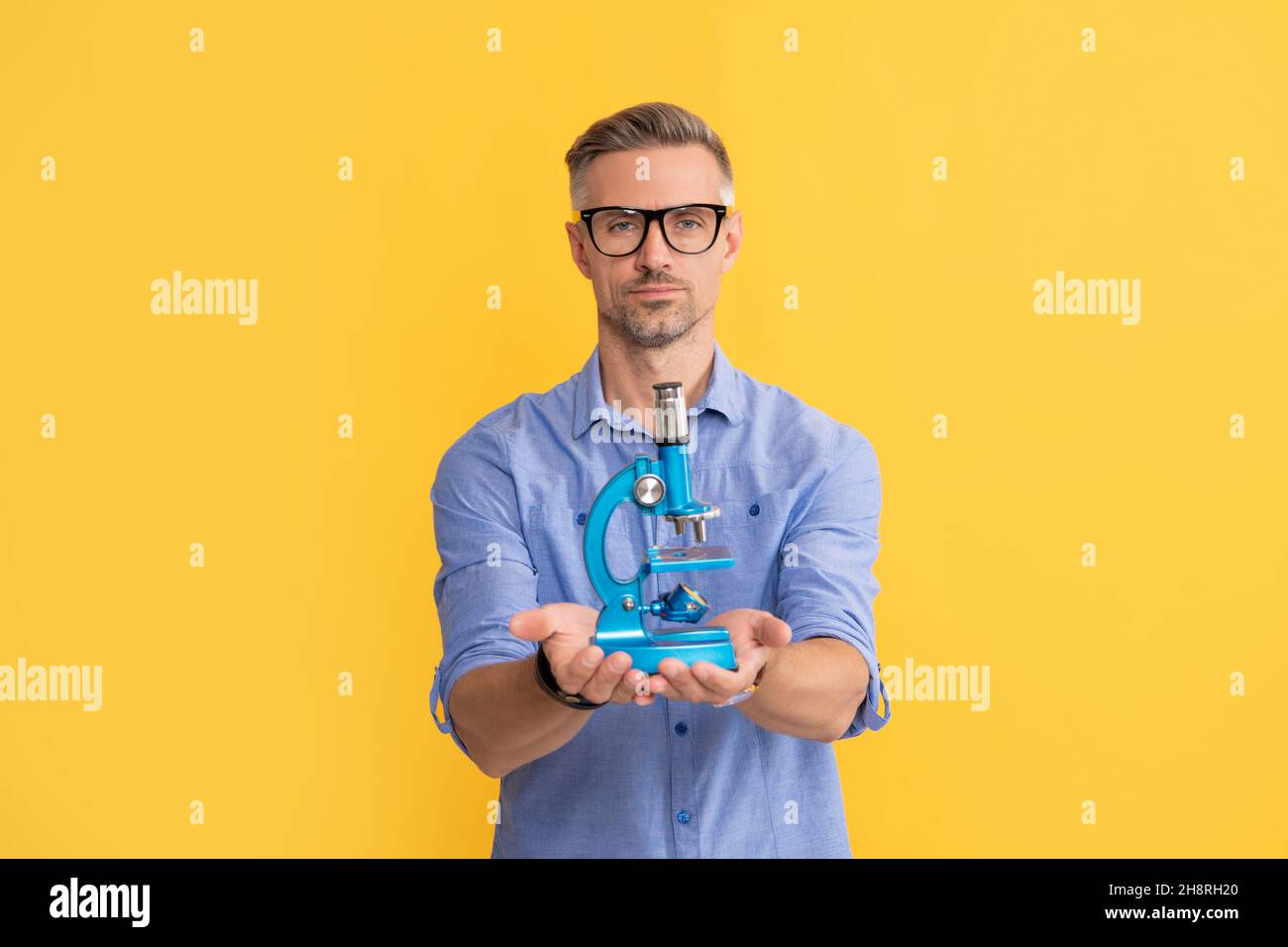 man in glasses hold microscope on yellow background, data science Stock ...