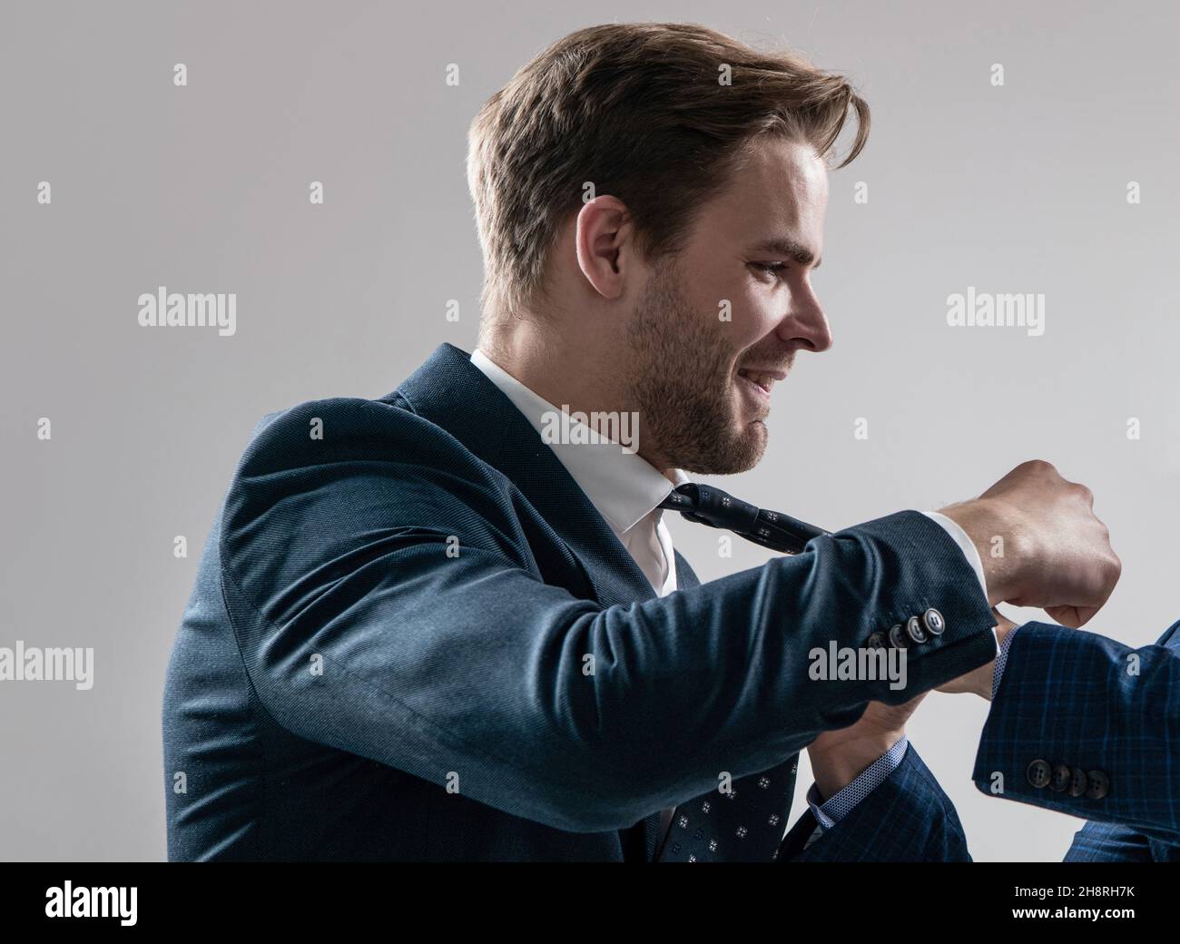 Punch given in response. Professional man punch being pulled by necktie ...