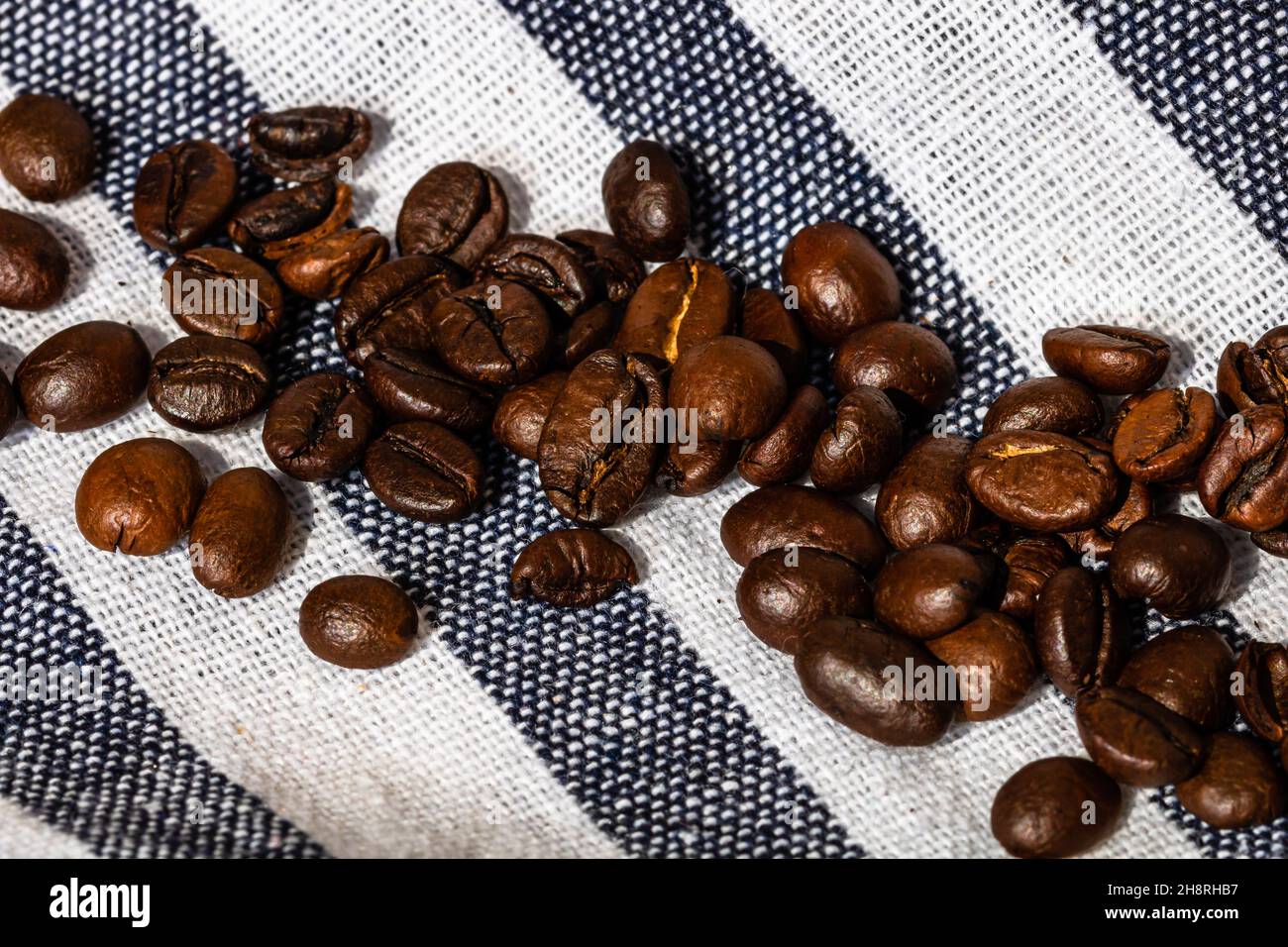 Top view of freshly roasted coffee beans on a napkin with blue and ...