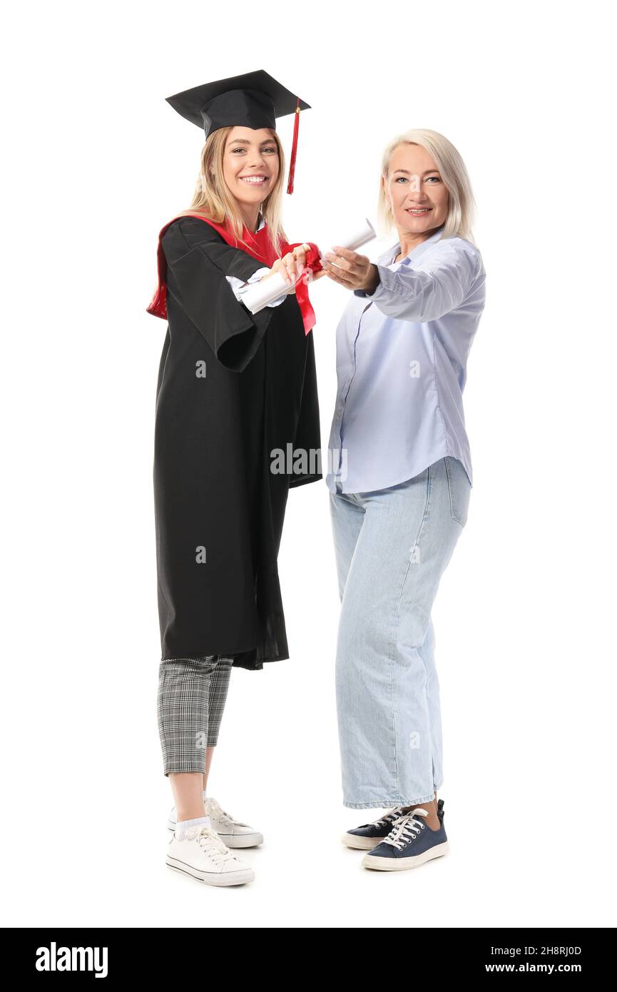 Happy female graduation student with her mother on white background ...