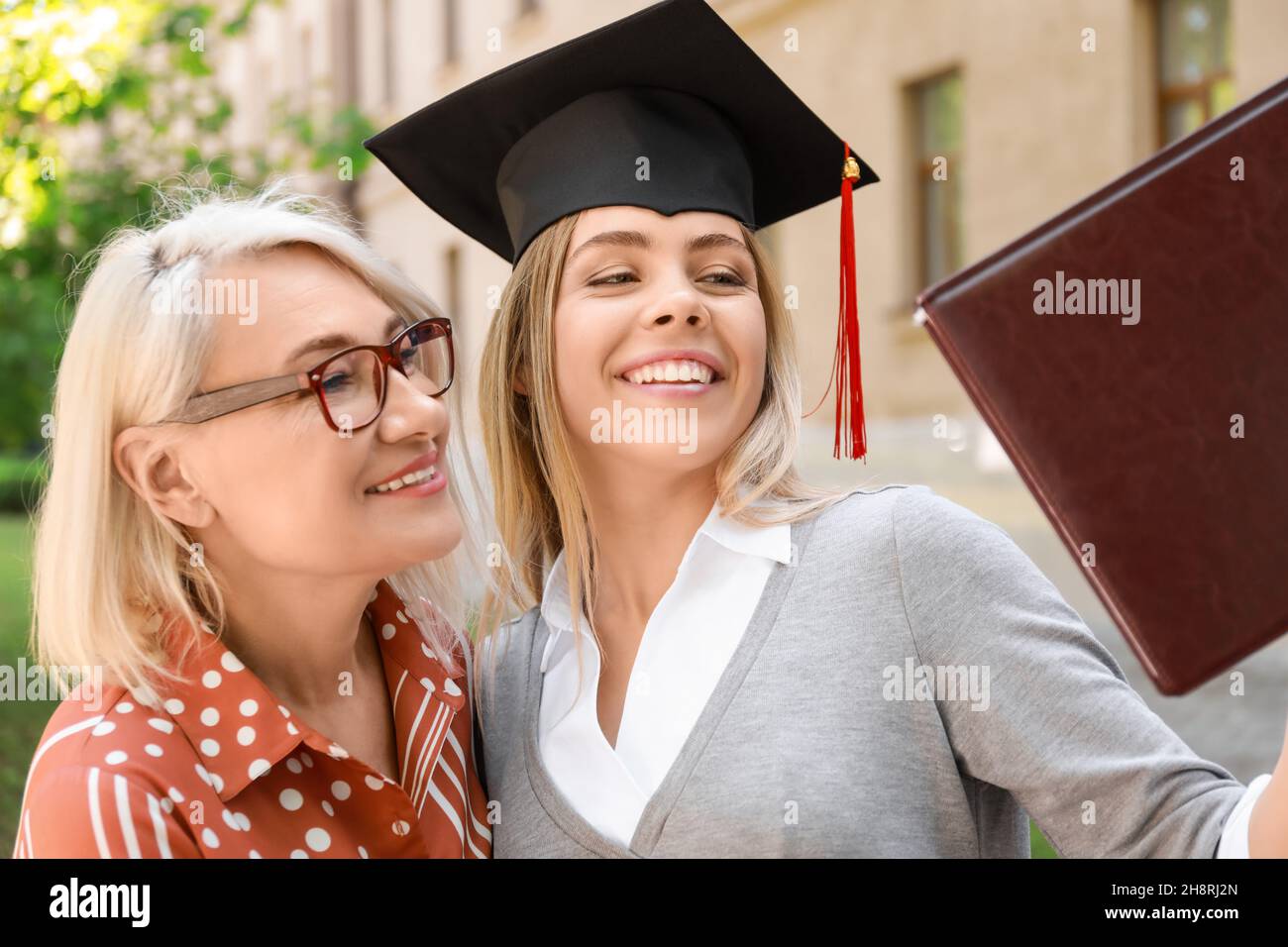 Happy young woman with her mother on graduation day Stock Photo - Alamy
