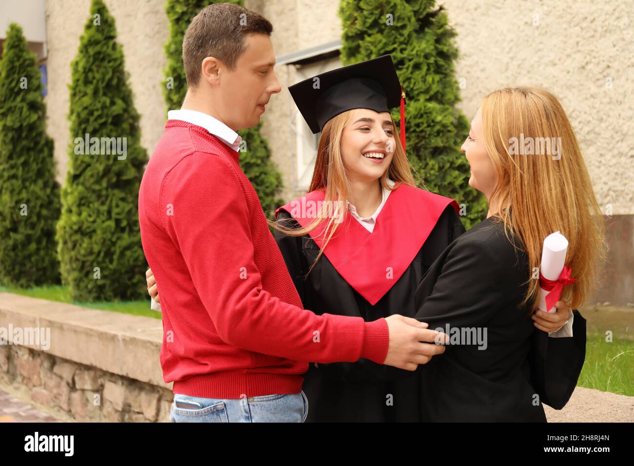Happy young woman with her parents on graduation day Stock Photo - Alamy