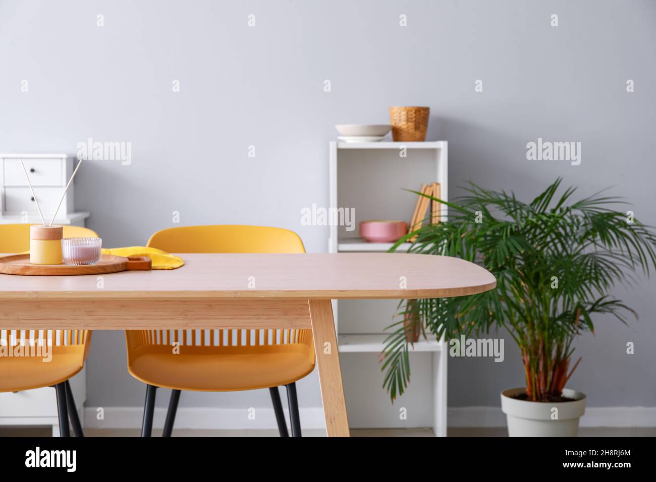 Dining table with reed diffuser and candle in interior of light room ...