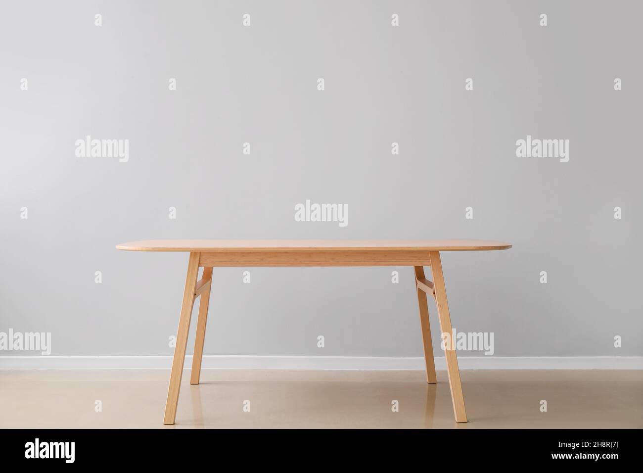Wooden dining table near light wall Stock Photo - Alamy