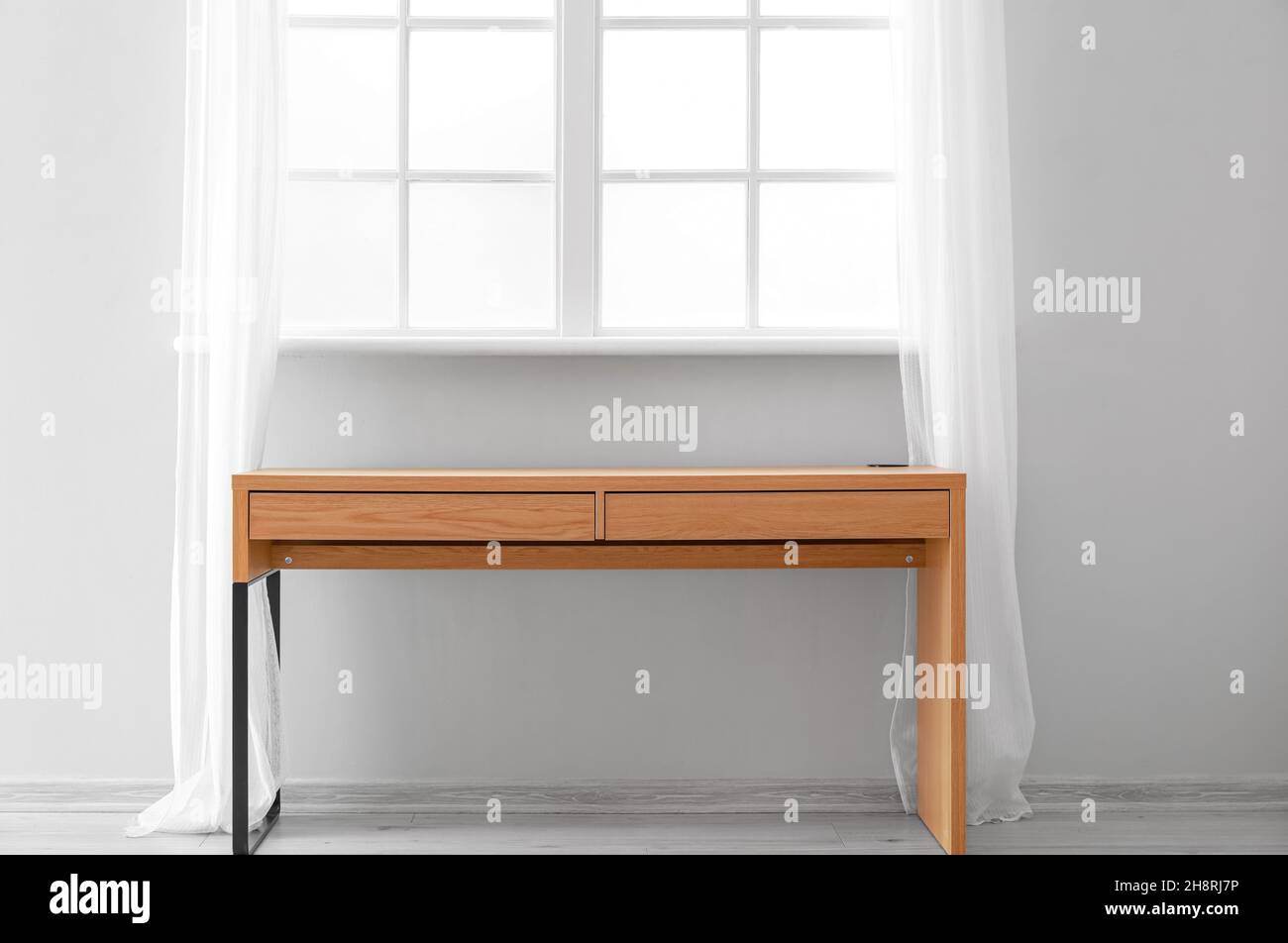 Empty wooden desk near light wall with window Stock Photo - Alamy