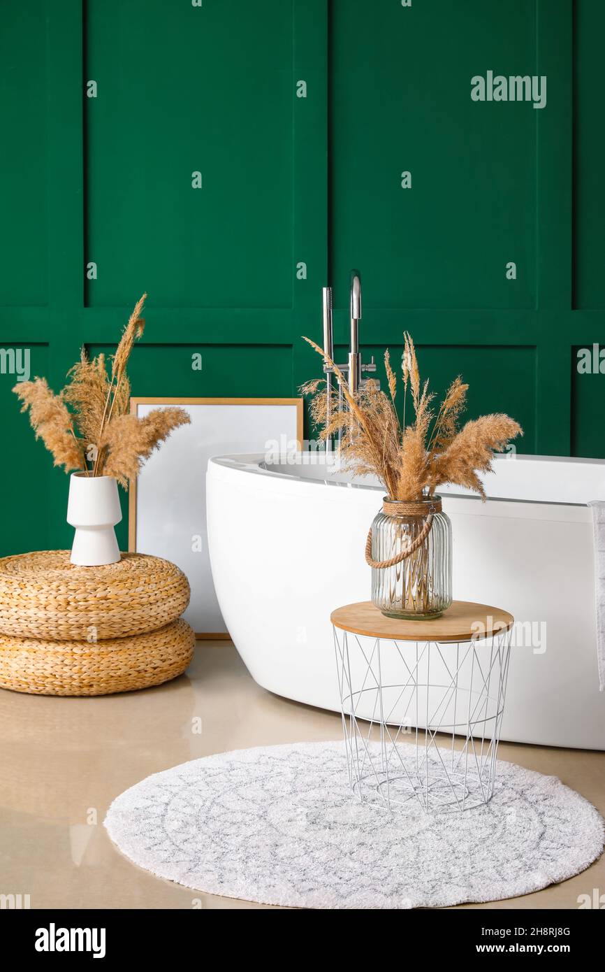 Vases with dry reeds in interior of stylish bathroom Stock Photo - Alamy