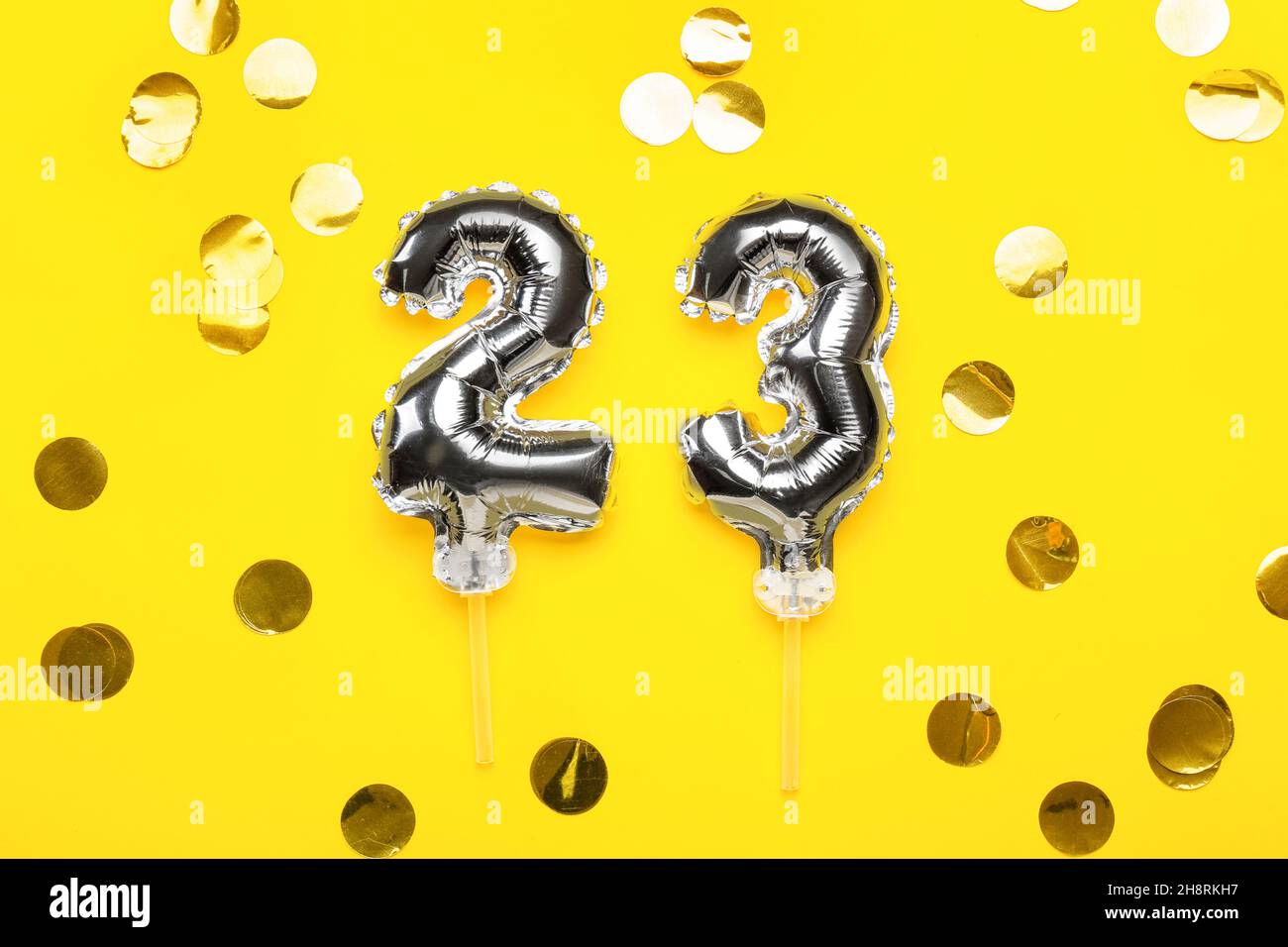 Figure 23 made of silver balloons and confetti on yellow background ...