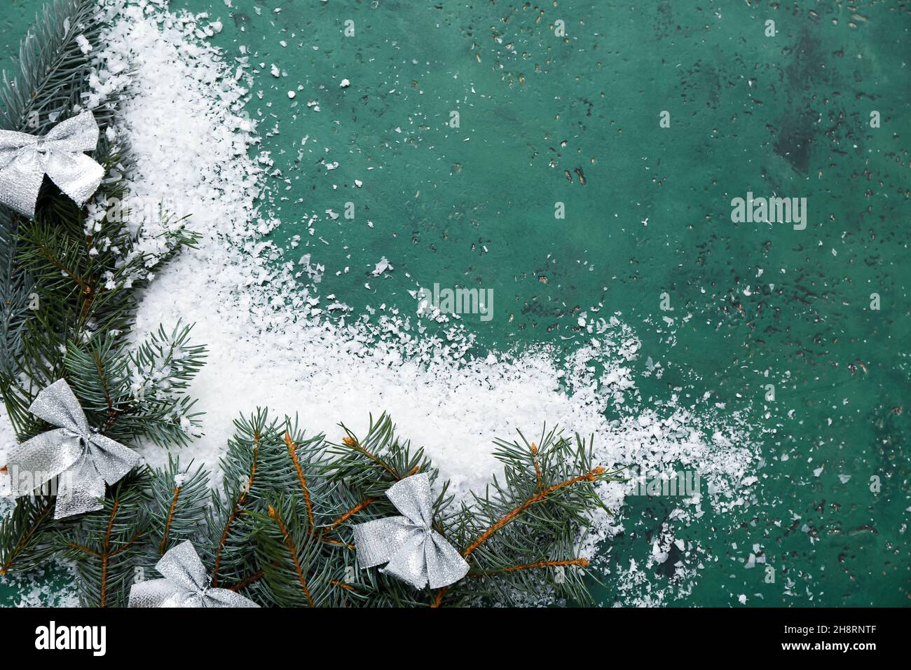 Fir branches, Christmas bows and snow on color background Stock Photo - Alamy
