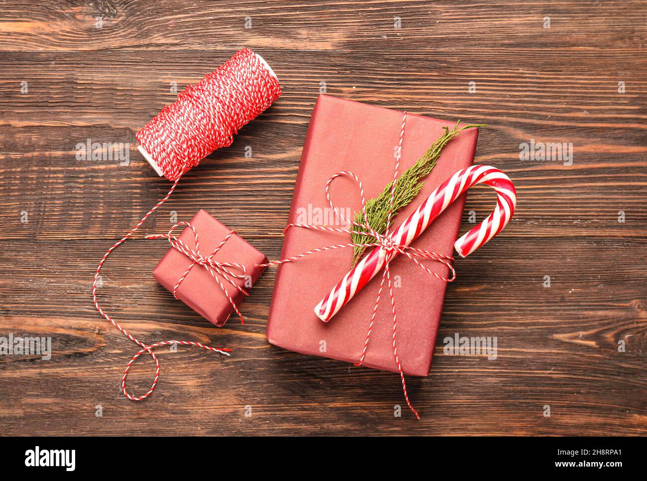 Christmas gifts decorated with candy cane and rope on wooden background ...