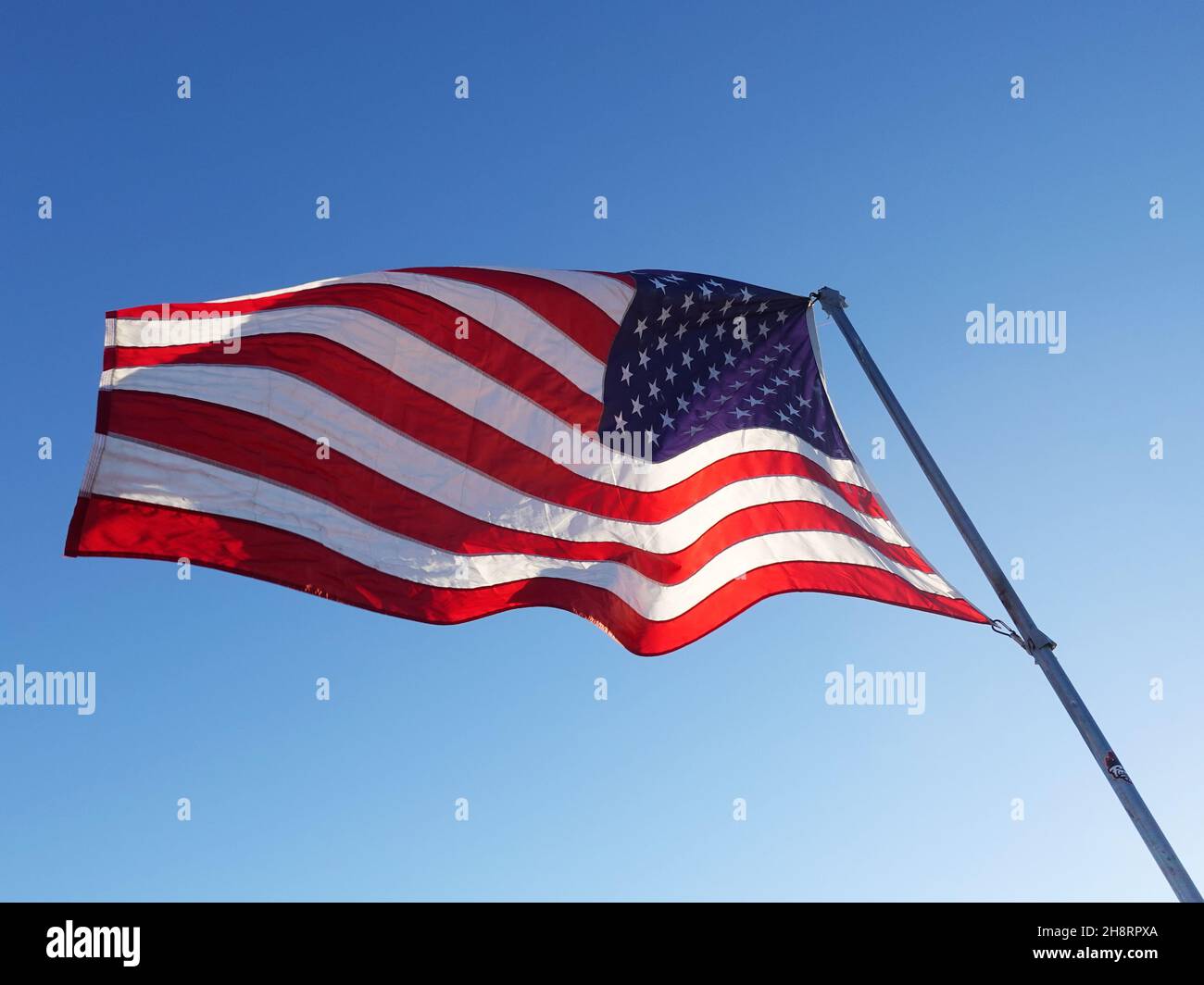 US flag waving overhead with blue sky background Stock Photo - Alamy