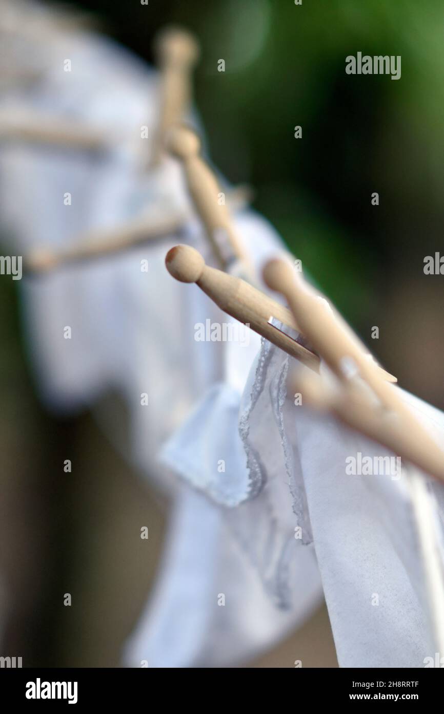 old fashioned wooden clothes pegs holding freshly washed white line on ...